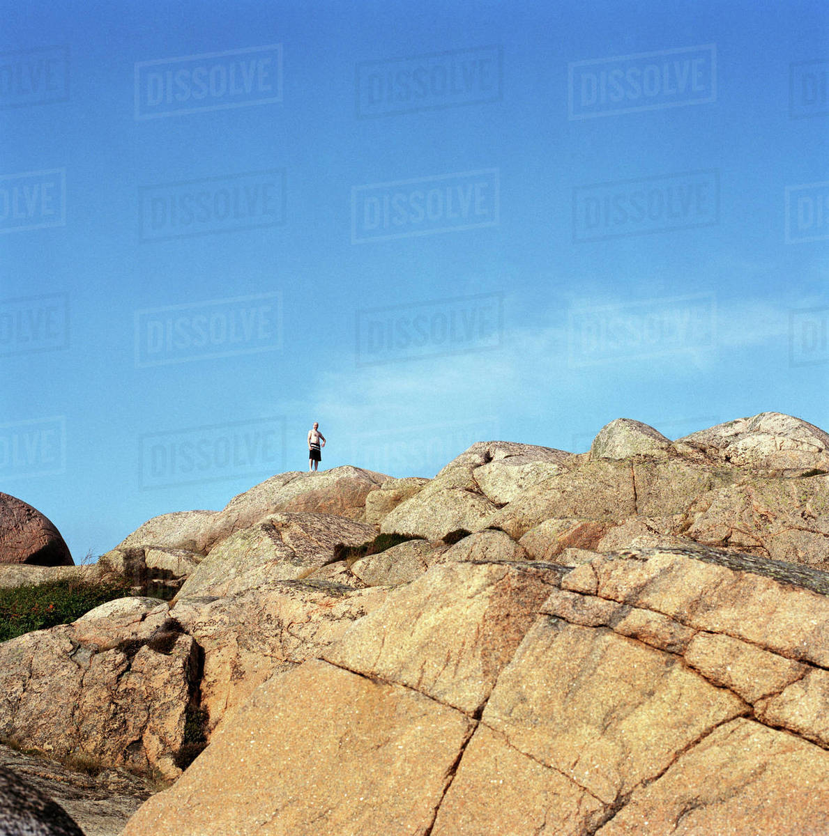 Person standing on rock - Royalty-free Stock Photo | Dissolve