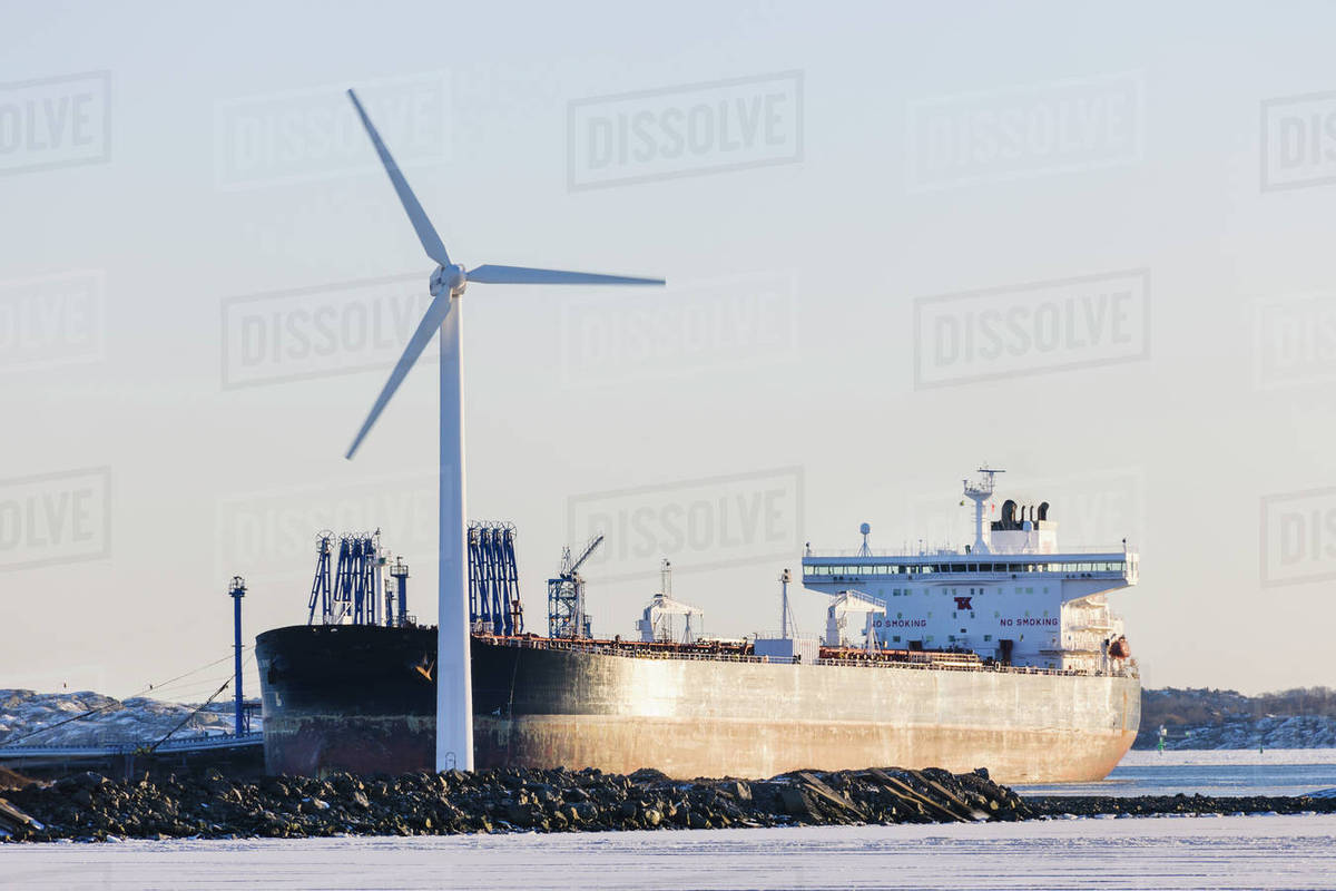 Wind turbine at coast, cargo ship on background - Royalty-free Stock ...