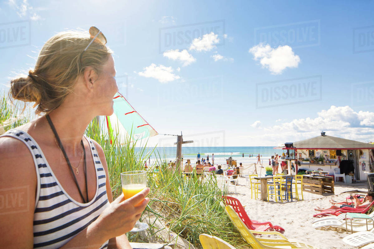 Woman looking at people on beach - Royalty-free Stock Photo | Dissolve