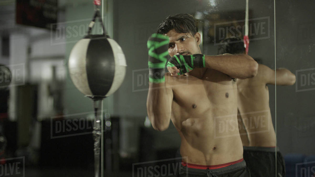 Selective focus view of boxer working out and training with punching ...