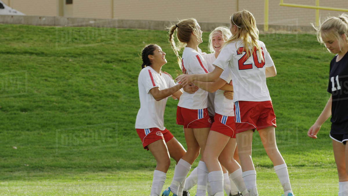 Proud athlete with soccer teammate cheering after game victory on field ...