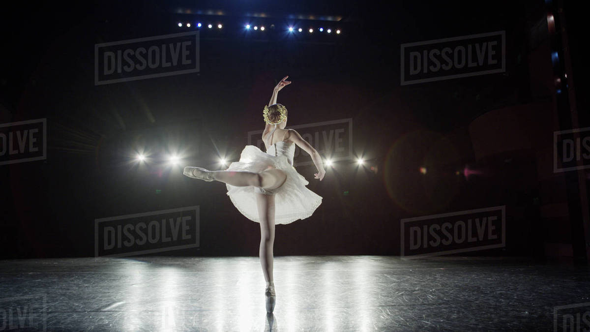 Rear view of serious ballet dancer in costume performing onstage in ...
