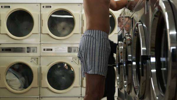 Man in underwear at laundromat - Stock Video Footage - Dissolve