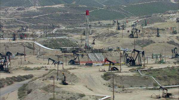 Oil Rigs Dirt Roads Hills. The shot shows oil wells extending for miles ...