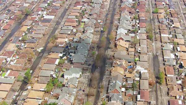 Wide shot POV aerial zoom in view of destructed area in suburban after ...
