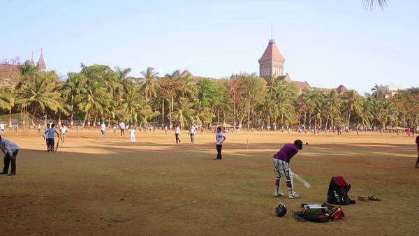 MUMBAI, INDIA - MARCH 2013: Group of people playing cricket in local ...