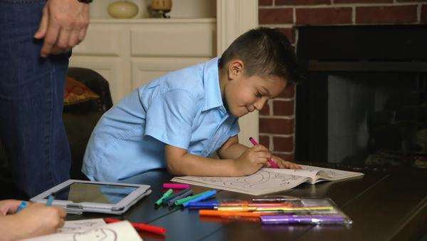 A cute little boy busy coloring in a coloring book. - Stock Video ...