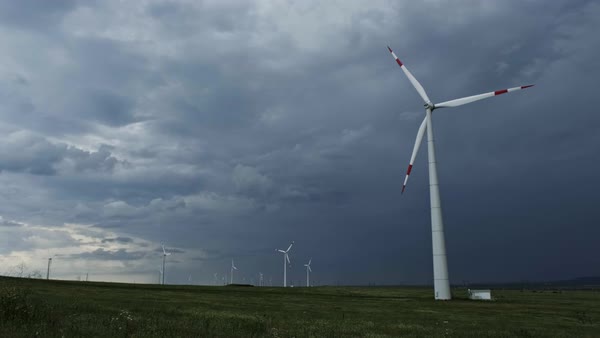 Windmill or wind turbine in rotation to generate electricity energy ...