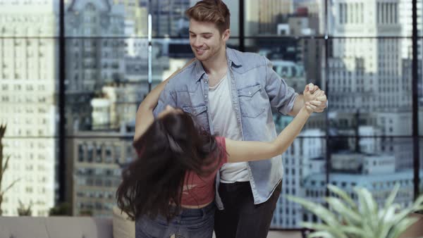 Young romantic couple dancing by the window in New York City apartment ...