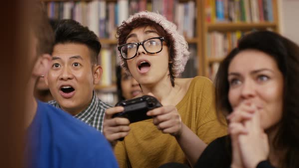 Large group of happy young friends hanging out and playing video games ...