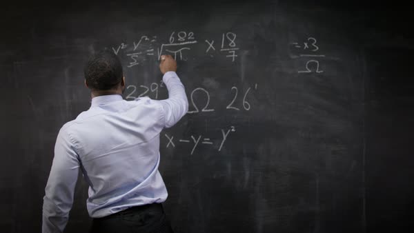 Young smiling teacher writing math formulas on blackboard. - Stock ...