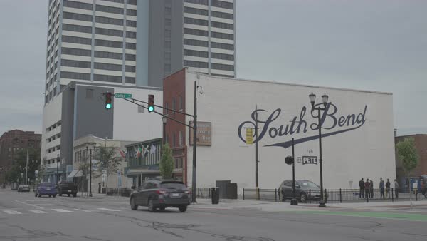 Wide shot of South Bend written on building by street in city, South ...