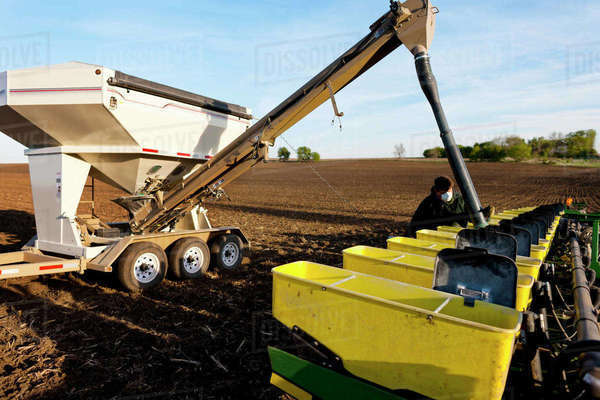 Agriculture - A farmer prepares for corn planting operations by loading ...