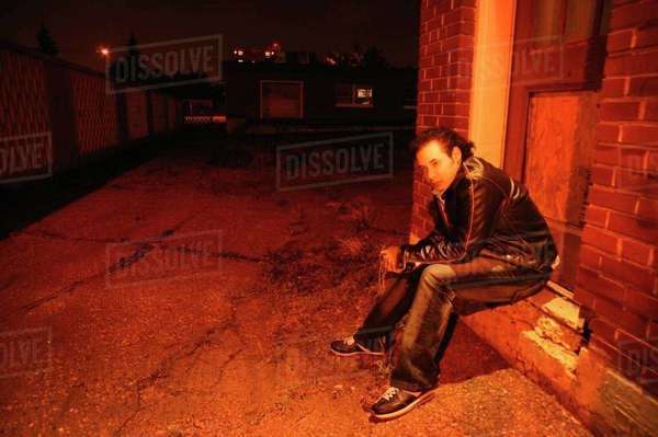 Man Sits Under Street Light - Stock Photo - Dissolve