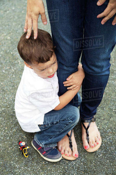 A young son holding on to his mother's leg; Chilliwack, British ...