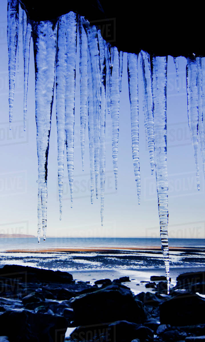 Icicles hanging down a cliff face; United Kingdom - Royalty-free Stock ...