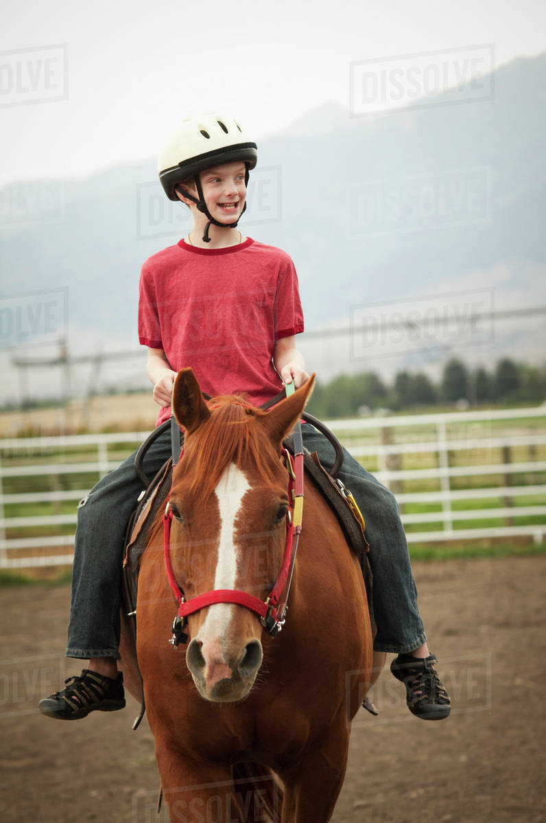 A young boy rides his horse at Eagle Mount; Bozeman, Montana, United ...