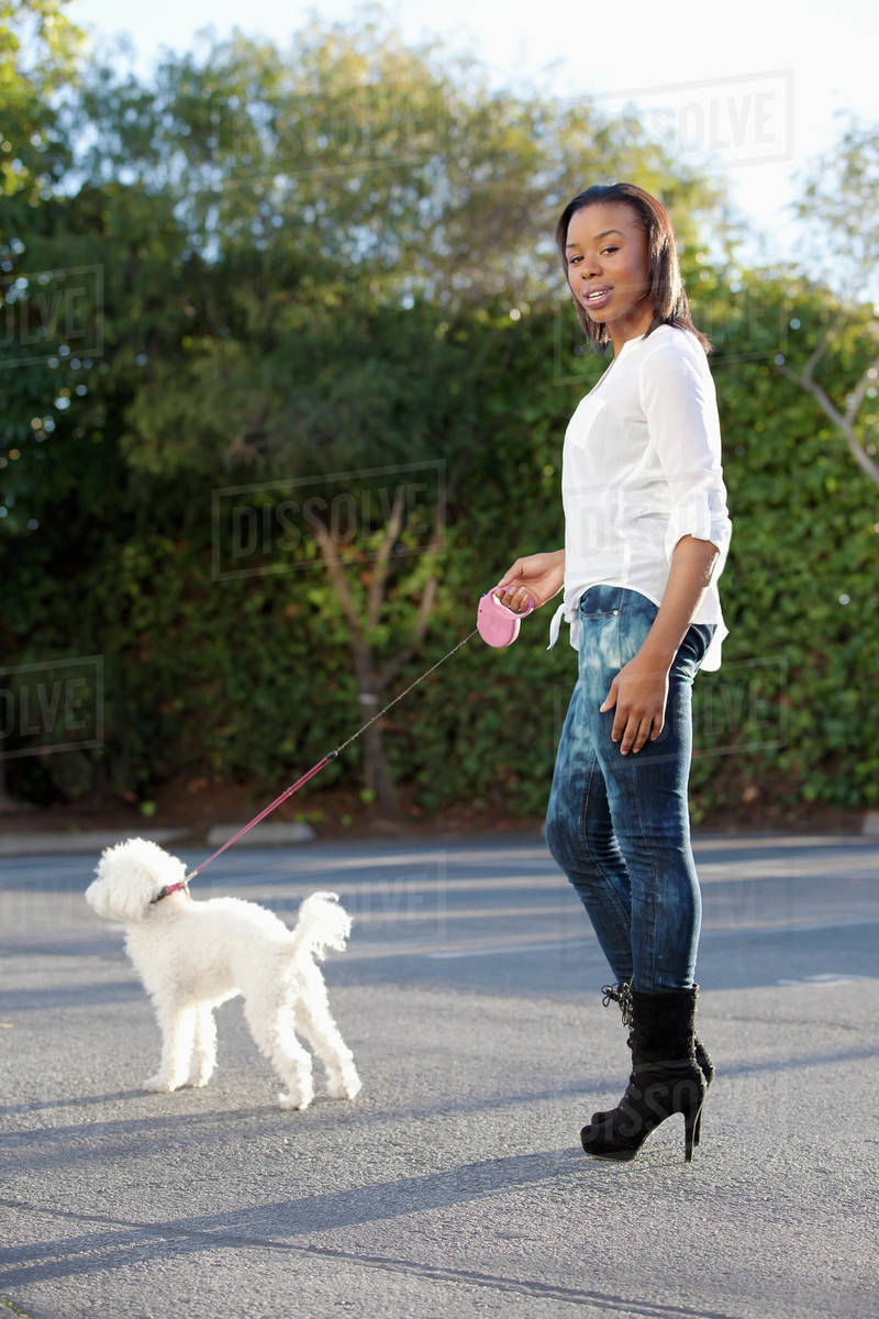 A woman walking her white dog; San Francisco, California, United States ...