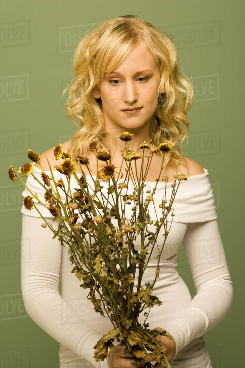 Lady Looking At Wilted Flowers - Stock Photo - Dissolve