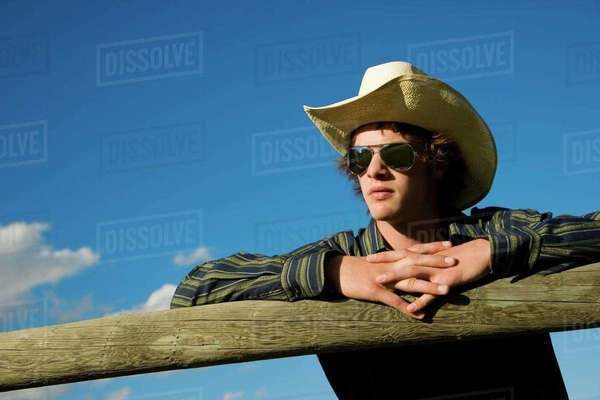Young Cowboy Leaning On Corral - Stock Photo - Dissolve