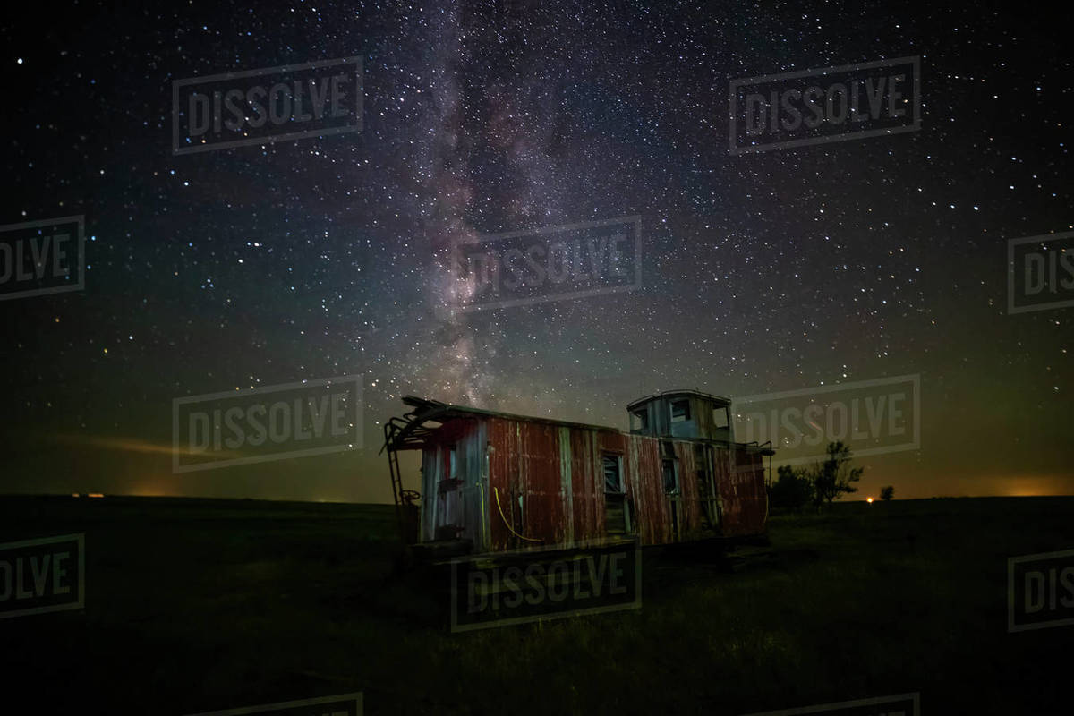 Old caboose at nighttime under a bright, starry sky; Coderre ...