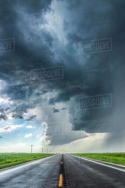 A developing severe thunderstorm with large hail crosses the highway in ...