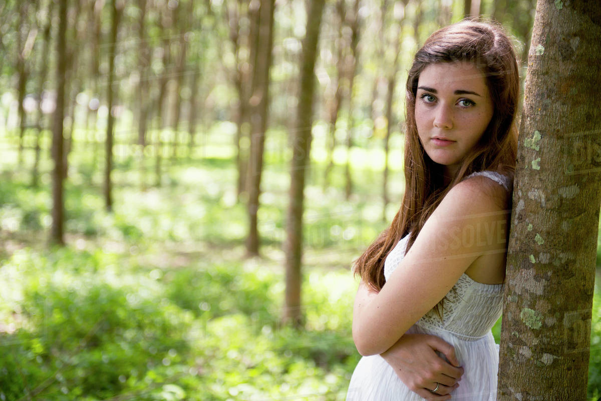 A girl in the woods leaning on a tree trunk;Phuket thailand - Royalty ...
