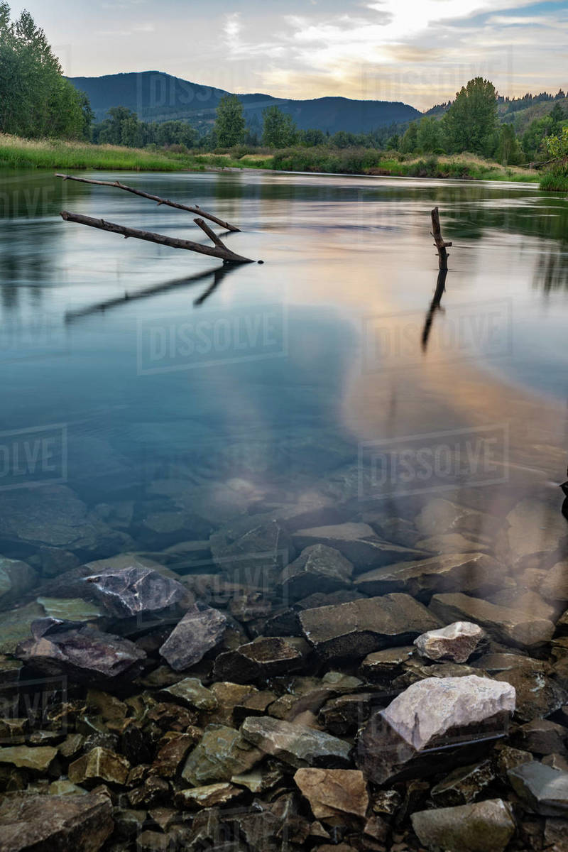 Rosey sunset clouds reflecting on the clear, smooth waters of the Coeur ...