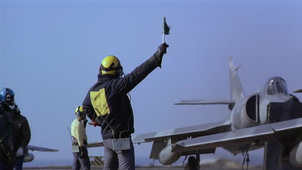 Crew member on aircraft carrier signaling for takeoff - HD Rights ...