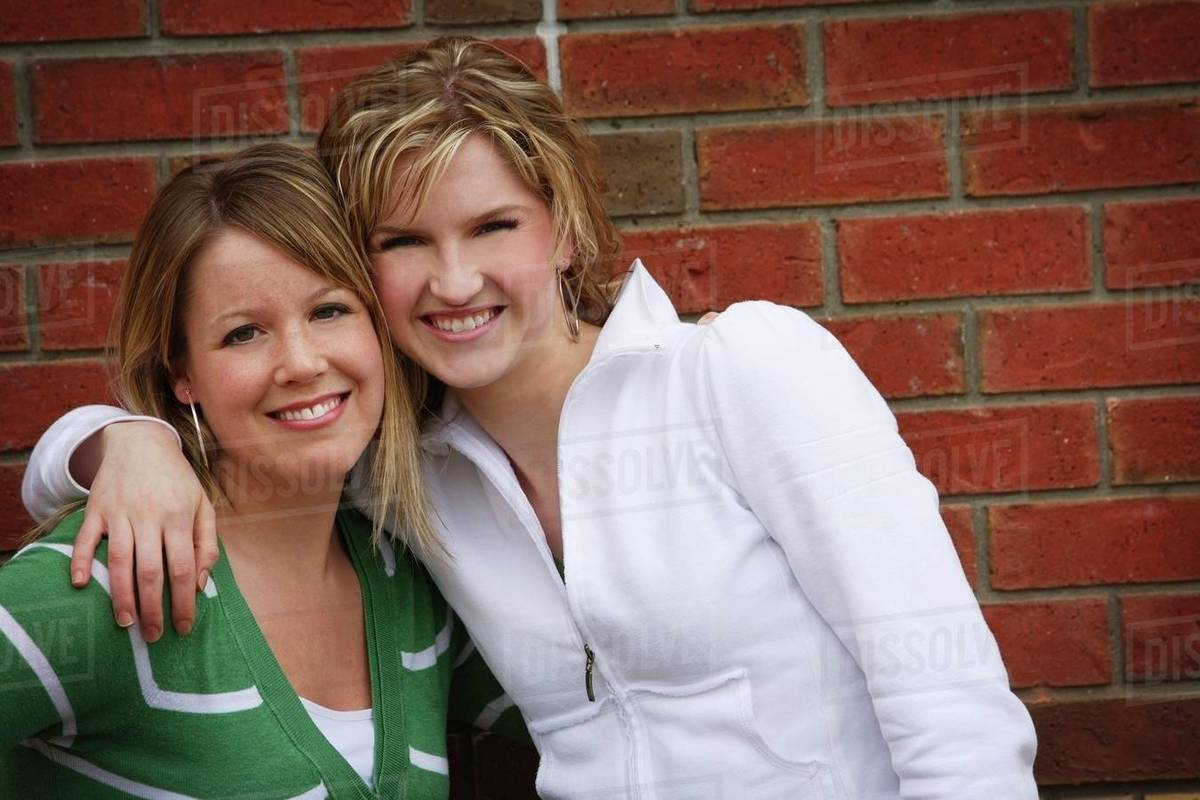 Two Women Smiling At The Camera - Royalty-free Stock Photo | Dissolve