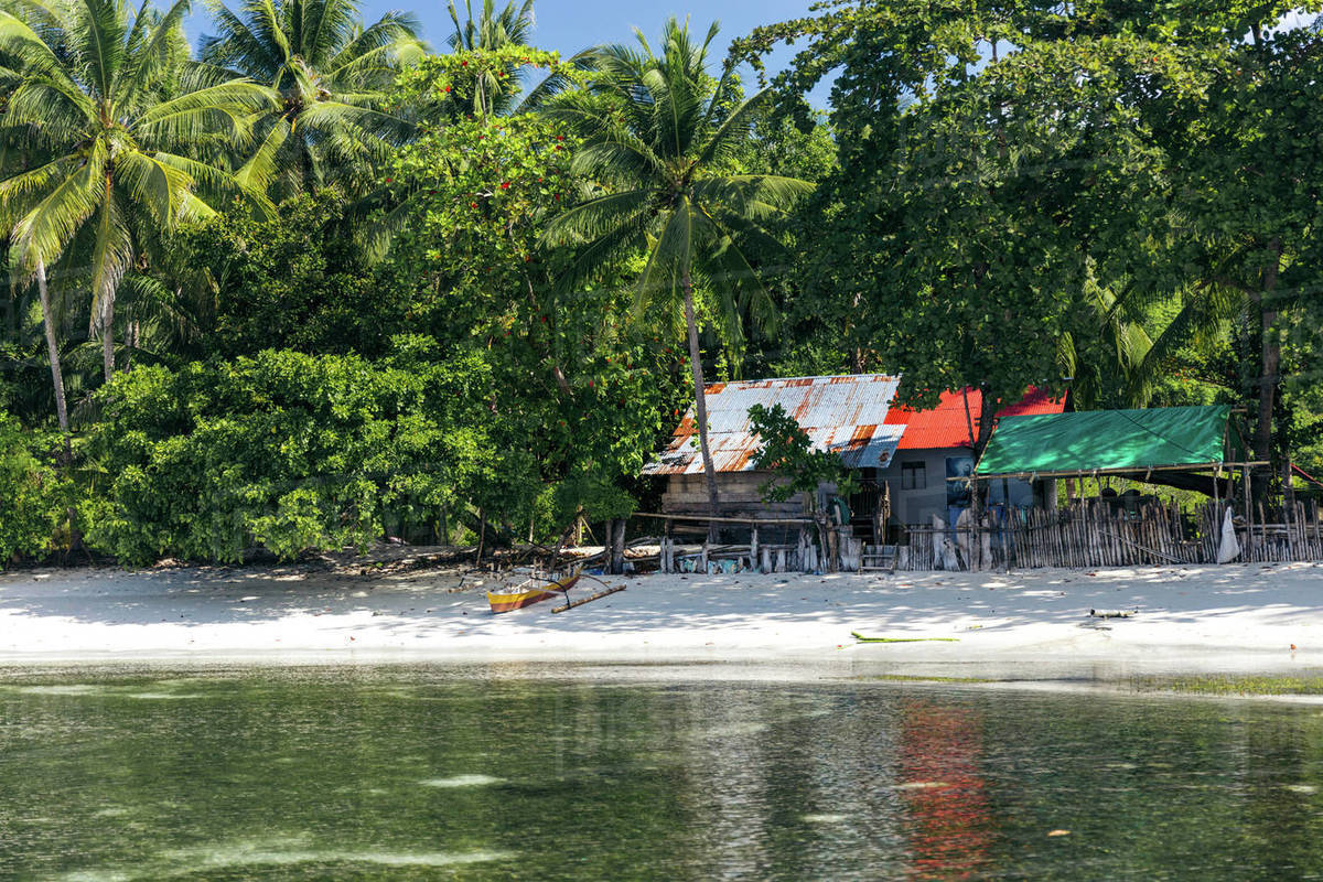 Patokan Beach (Jiko) with palm trees and buildings along the water's ...