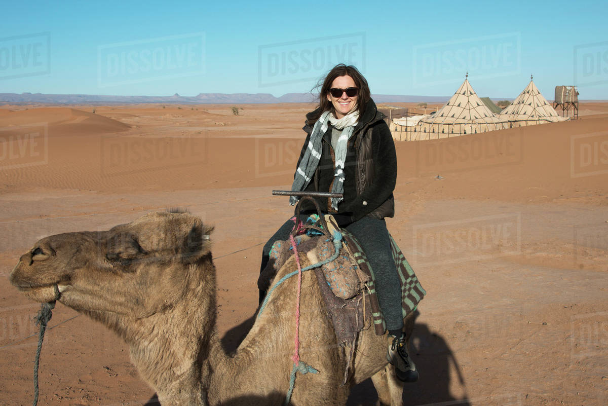 A woman riding a camel on the erg chegaga dunes;Souss-massa-draa ...