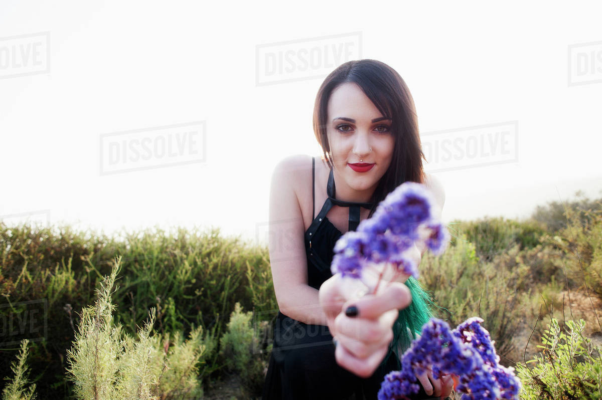 A Young Woman Presenting A Purple Flower To The Viewer; California ...