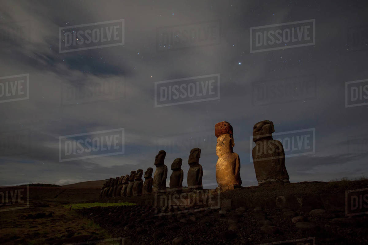 Moai stand as silhouettes beneath the night sky on Easter Island at ...