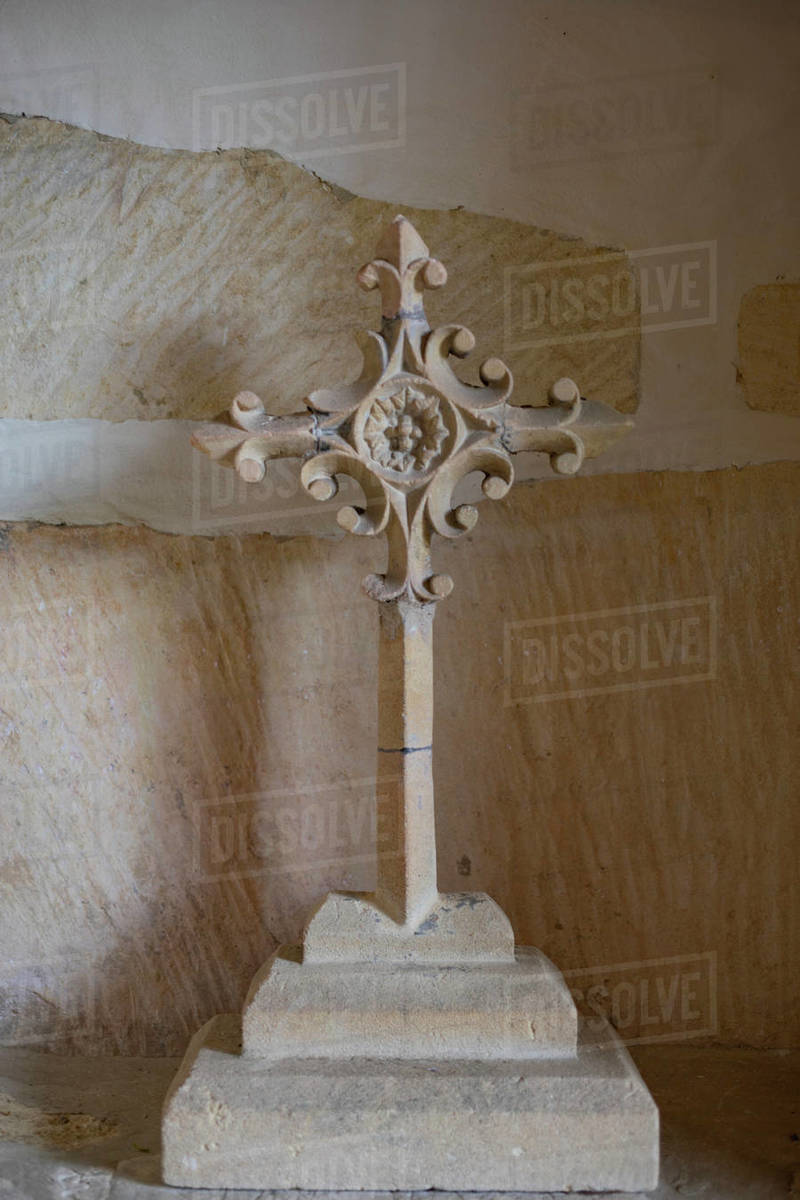 Close-up of decorative metal cross on stone base; Ampney Crucis ...