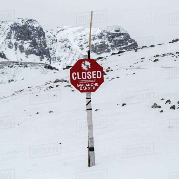 A red sign indicating a ski area is closed due to dangerous avalanches ...