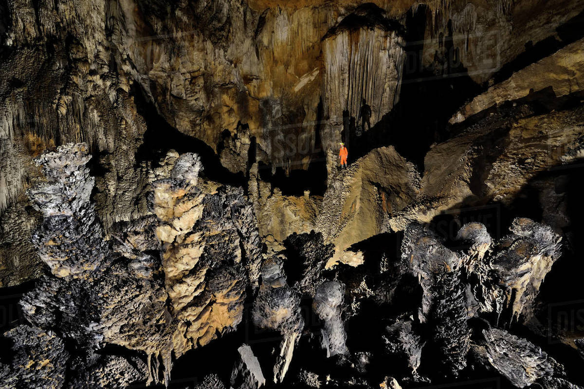 Calcified stalagmites grow on a ledge overlooking a large passage in ...