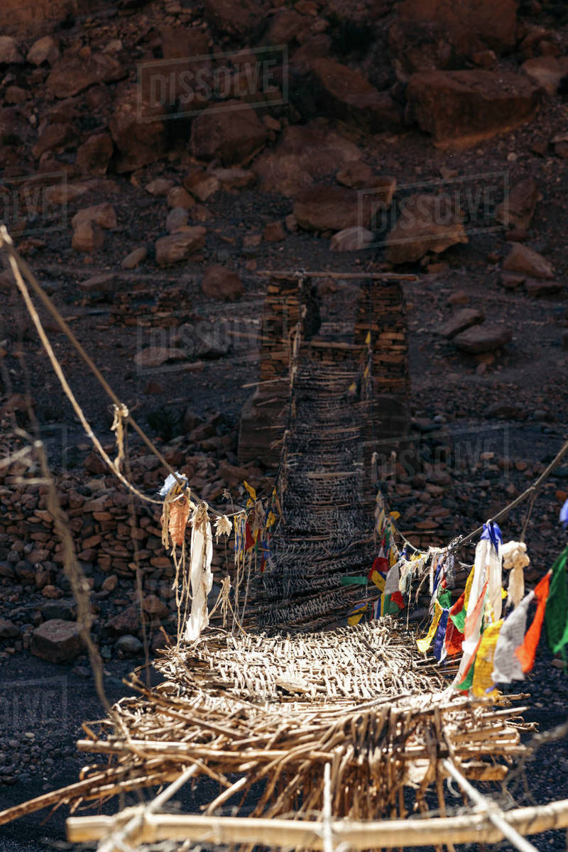Bridge with Buddhist prayer flags crossing a river at Phuktal Gompa ...