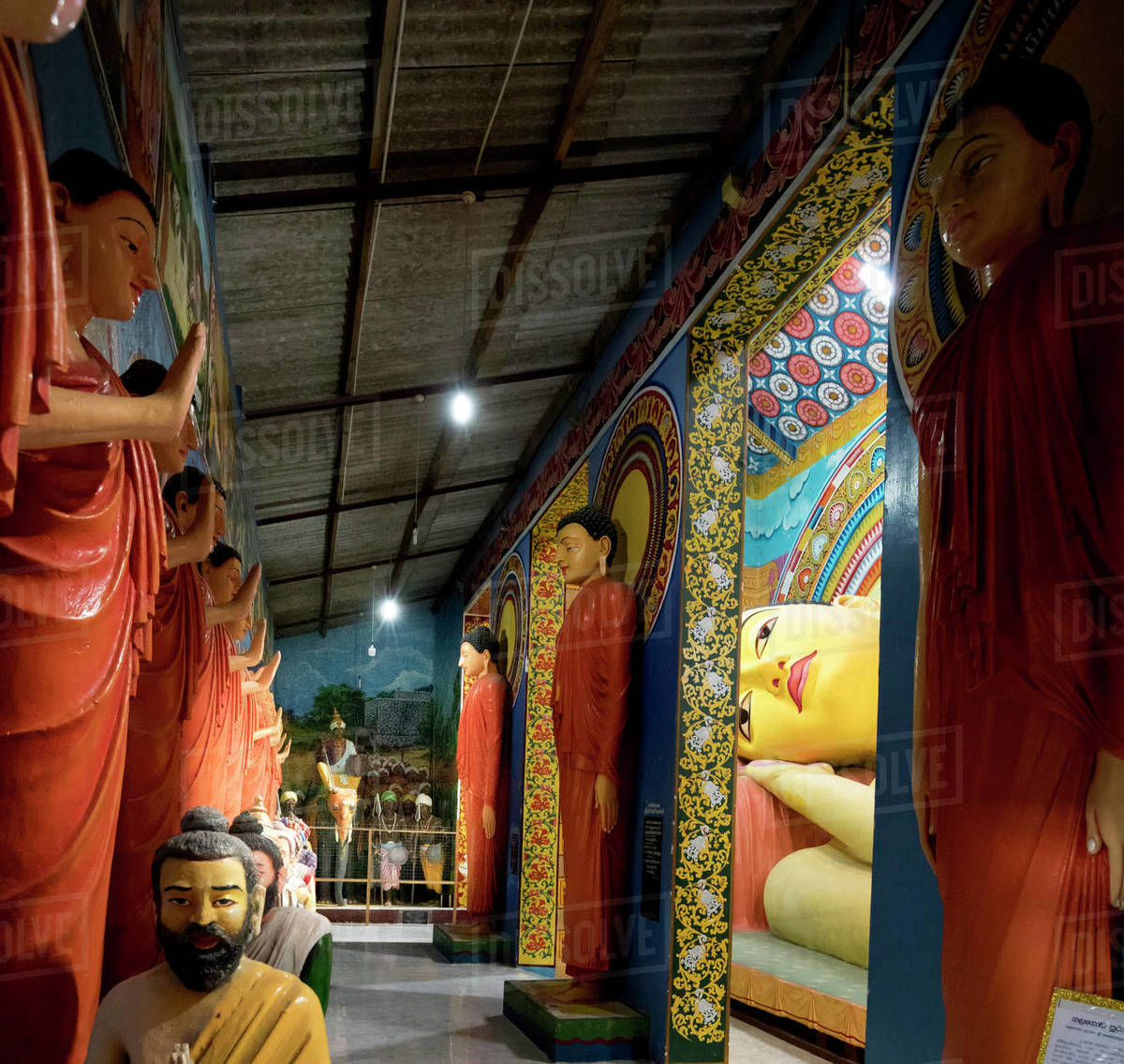 Hallway lined with statues of Standing Buddhas and sculptures of holy ...