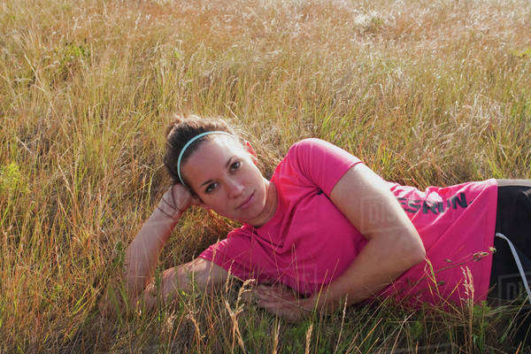 Woman Propped Up On Her Elbow On Hillside, Manitoba, Canada - Royalty ...