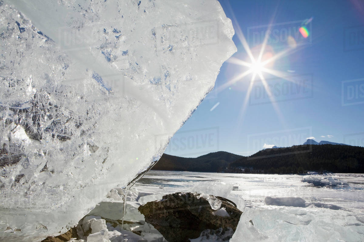 Ice Formation On Shoreline Of A Mountain Lake With A Sunburst And Blue ...
