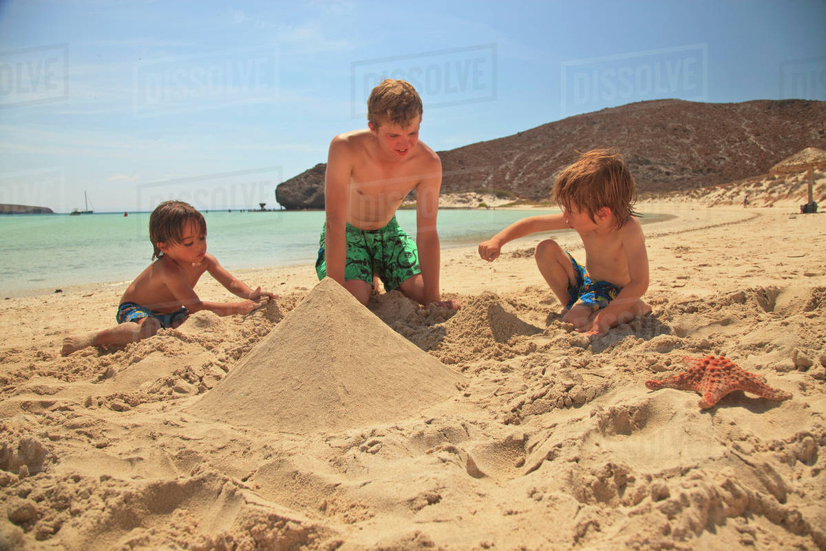 Three Boys Play In The Sand At The Water's Edge At Los Islotes National ...