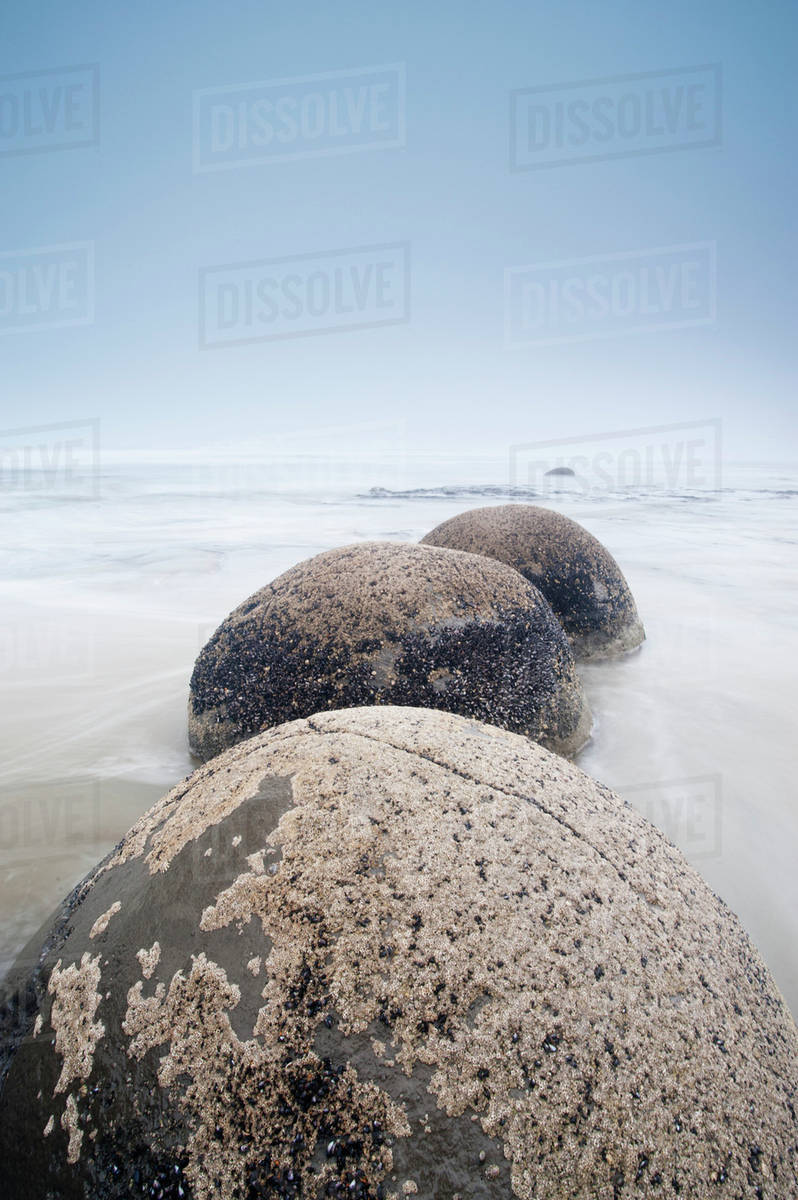 Boulders In A Row In The Shallow Water Leading Out To The Ocean From ...