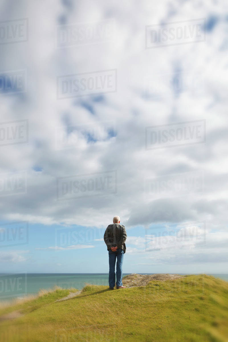 Man Standing Alone On A Hill Staring At The Ocean At Inchydoney Beach ...