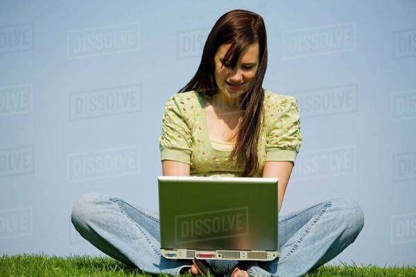 A Girl Working In The Park On Her Laptop Computer - Stock Photo - Dissolve