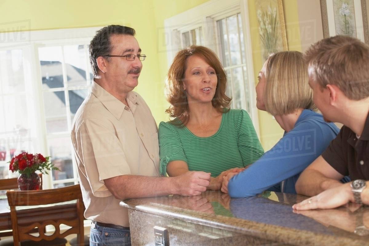 A Family Having A Conversation In The Kitchen - Stock Photo - Dissolve