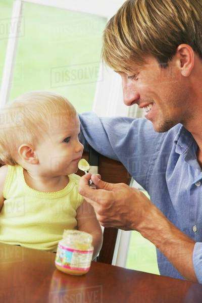 A Father Feeding His Young Daughter - Stock Photo - Dissolve