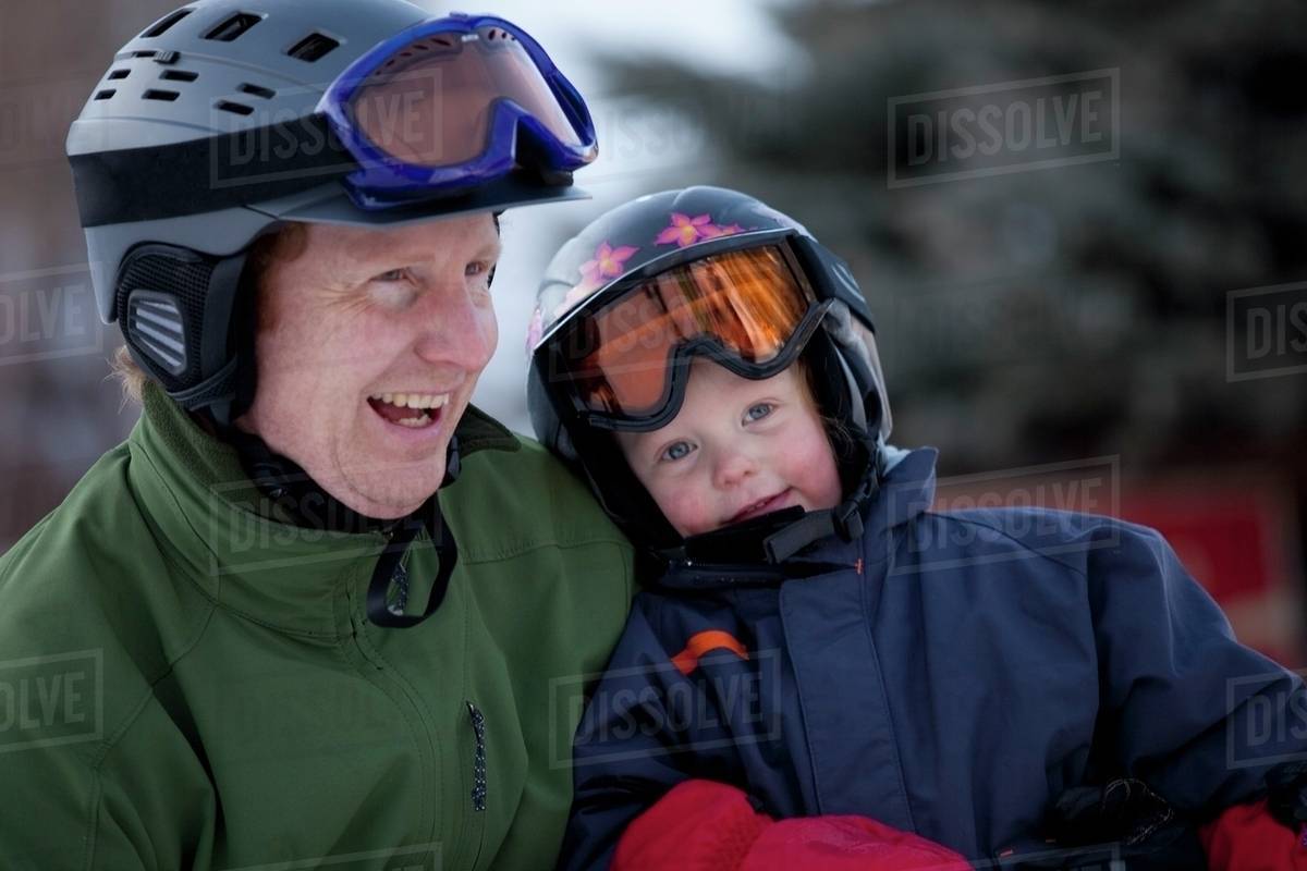 A Father And Young Son Wearing Helmets And Ski Masks; Red Deer, Alberta ...