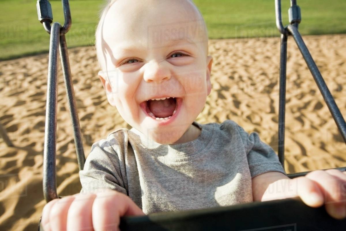 Boy In A Swing - Stock Photo - Dissolve