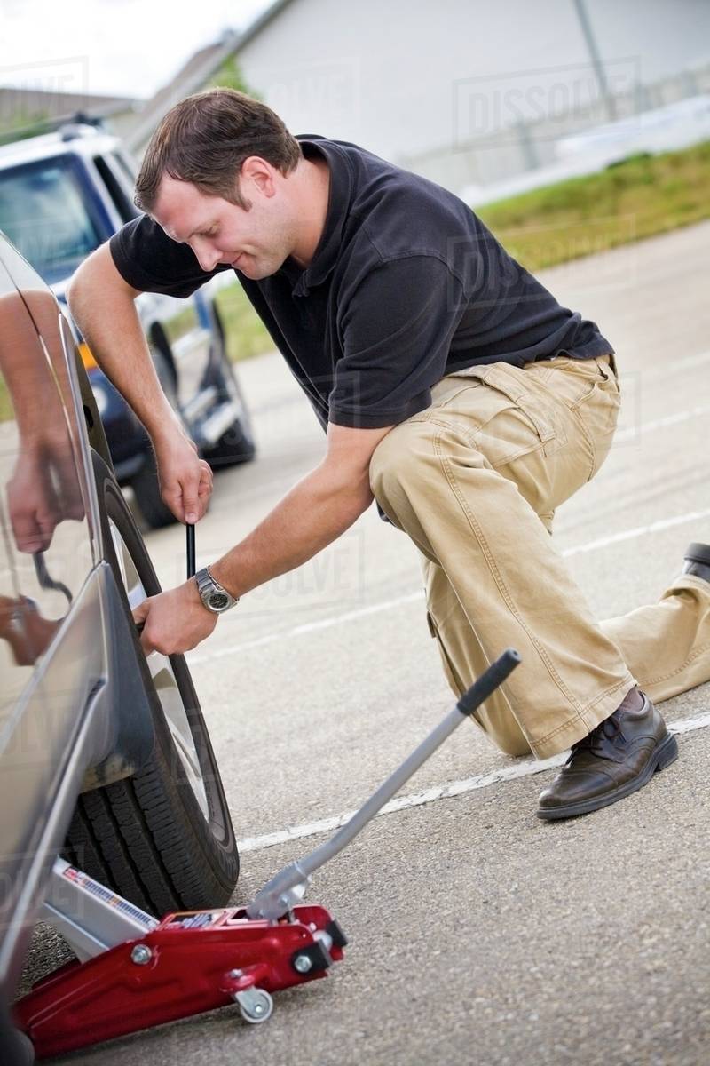 Man Changing A Tire - Royalty-free Stock Photo | Dissolve